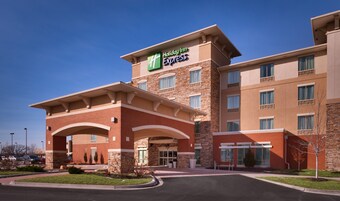 Edifício Holiday Inn Express com fachada de tijolos, várias janelas e céu claro.