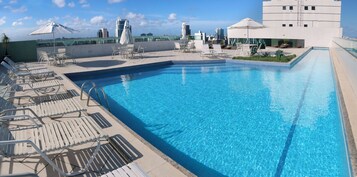 Piscina externa, guarda-sóis, espreguiçadeiras