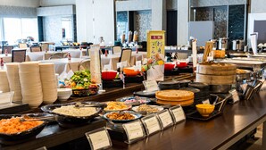 Disposição de buffet com diversos alimentos e utensílios de servir.