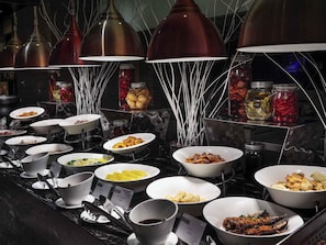 Uma mesa de buffet com diversos pratos e acompanhamentos.