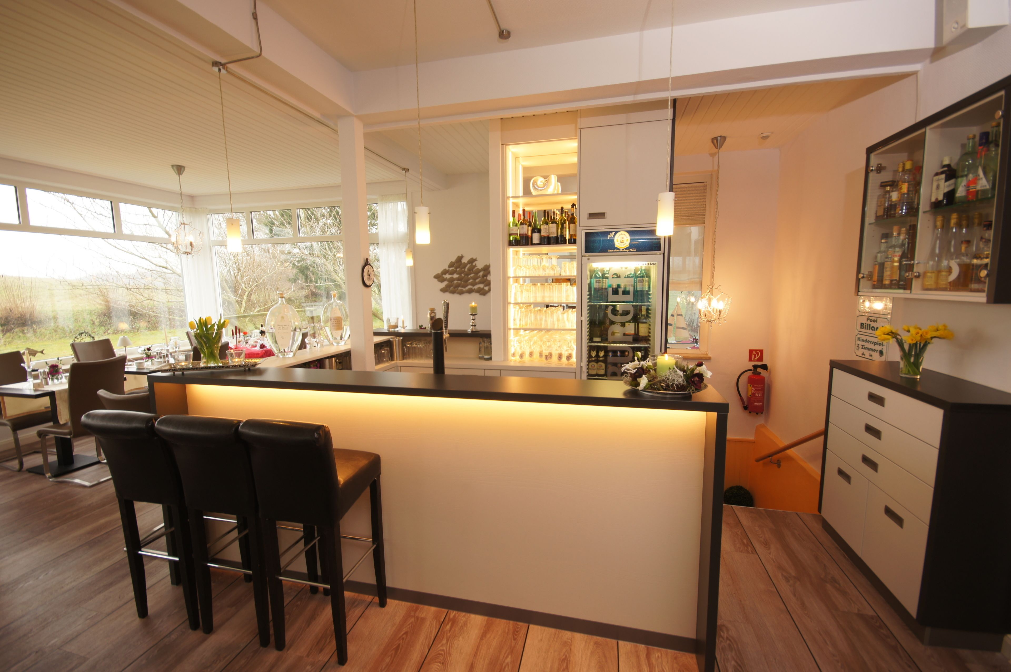 Uma cozinha moderna com ilha central, espaço para bar e adega.