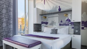 Quarto moderno com uma cama grande, um banco e uma parede com arte urbana.