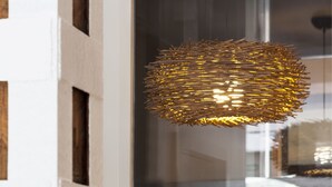 Um balcão de atendimento com uma luminária moderna e uma divisória de vidro.