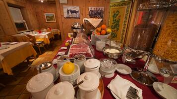 Uma mesa de buffet com diversos alimentos e utensílios de servir.