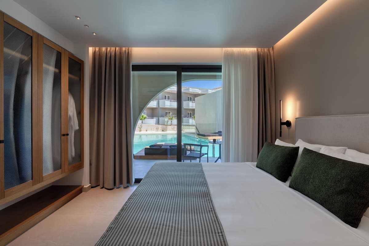 Quarto de hotel com cama, vista para a piscina e varanda.