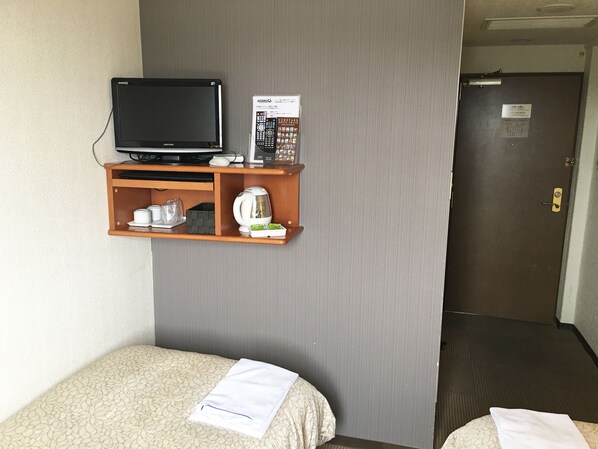 Quarto de hotel com televisão, minibar e porta.
