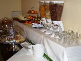 Uma mesa de buffet com diversos alimentos e utensílios de servir.
