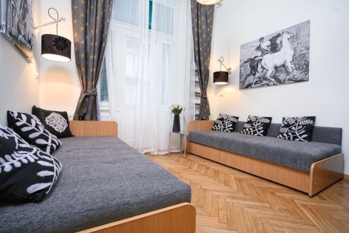 Uma sala de estar moderna com sofá, cama e mesa de jantar.