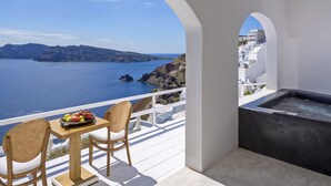 Varanda com mesa posta para dois, com vista para a paisagem costeira.