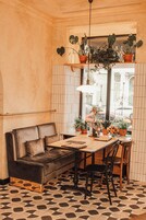 Um espaço aconchegante com sofá, mesa de jantar, cadeiras e plantas em vasos.