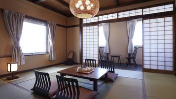 Um quarto japonês tradicional com piso de tatame, uma mesa baixa com almofadas e portas corrediças shoji.