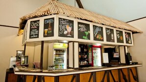 Uma área de bar com um quadro de menu exibindo opções como 'Sam's Special' e 'Fruit Punch'.