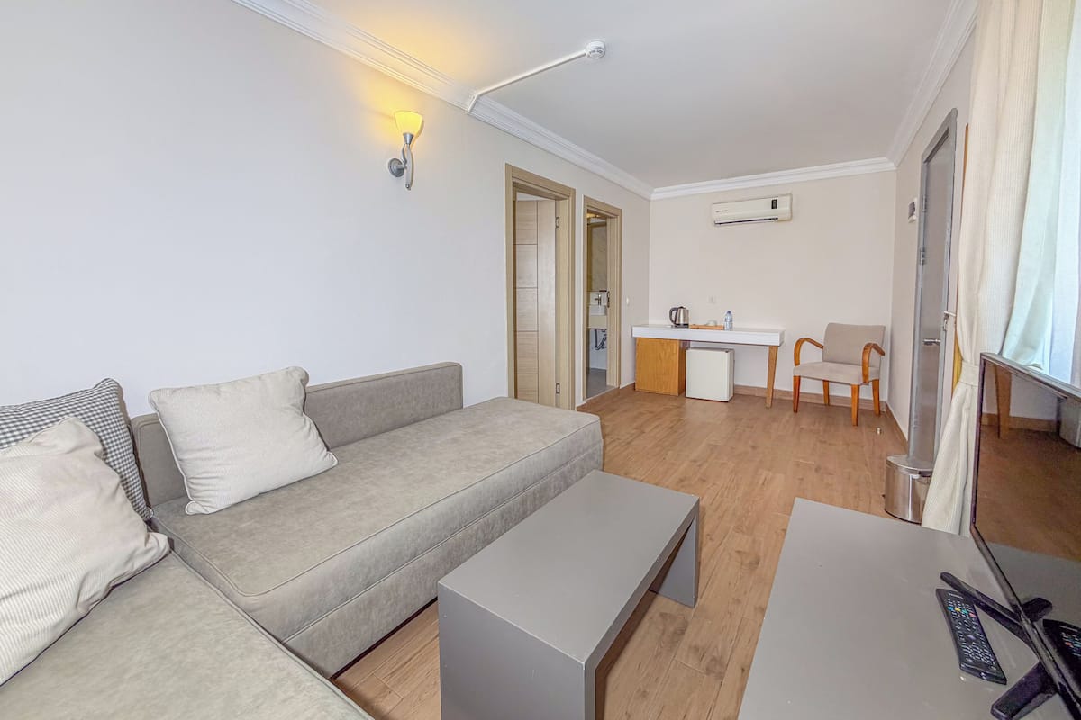 Uma sala de estar moderna com sofá, mesa de centro e área de jantar com mesa e cadeiras.