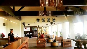 Um hall amplo com balcão de recepção, área de estar e bar.