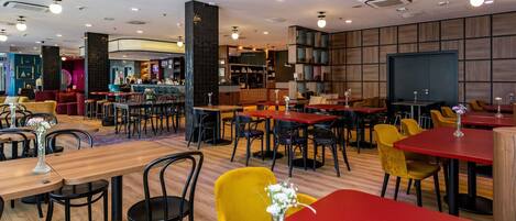 Restaurante moderno com várias áreas de refeição, incluindo um bar e um espaço com lareira.