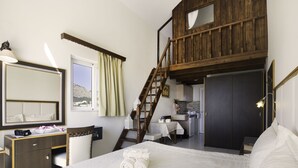 Quarto com cama, escrivaninha, espelho, guarda-roupa, escada e pequena cozinha.
