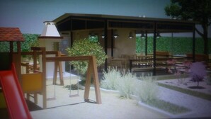 Um edifício moderno com área externa coberta, incluindo assentos e balanço.
