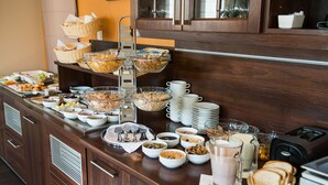 Disposição de buffet com diversos alimentos e bebidas.