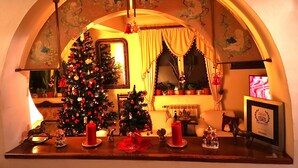 Um quarto acolhedor com árvore de Natal, lareira e espelho.