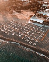 Na praia, praia de areia negra, espreguiçadeiras, guarda-sóis de praia 