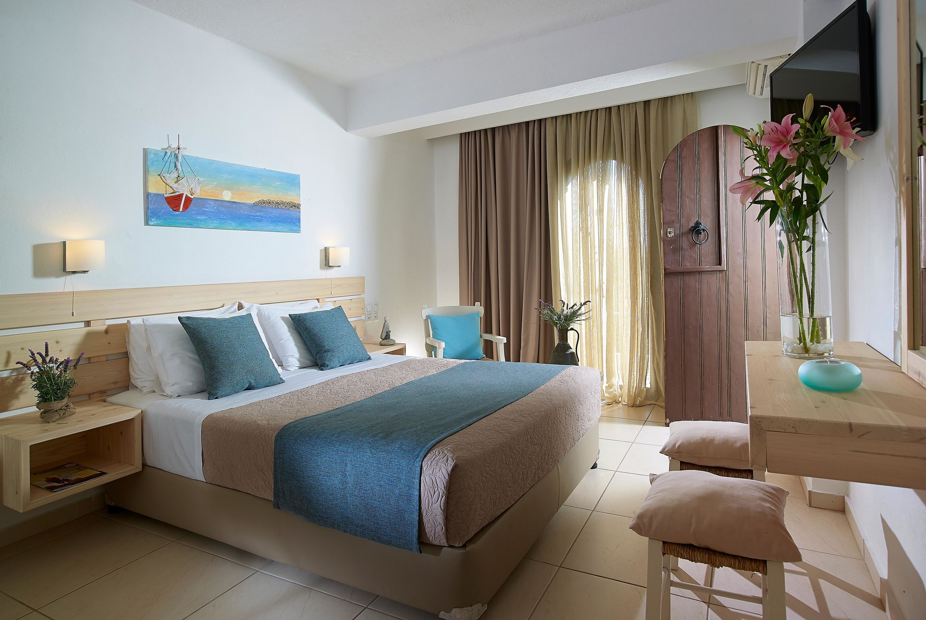 Quarto de hotel moderno com uma cama grande, mesas de cabeceira, uma escrivaninha e uma televisão.