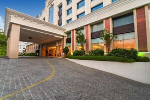 Entrada de hotel com um caminho de pedras que leva ao edifício principal.