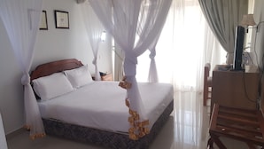 Uma cama bem arrumada com cabeceira de madeira, mesa de cabeceira e abajur.