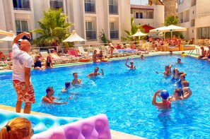 Uma área de piscina com espreguiçadeiras e guarda-sóis.