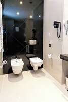 Uma casa de banho moderna com bidé, sanita e lavatório.