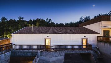 Um edifício moderno com telhado em cerâmica, duas portas e cerca de madeira.