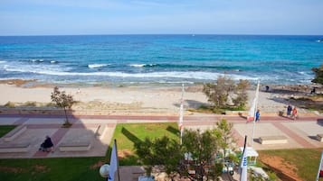Na praia, praia de areia branca, espreguiçadeiras, guarda-sóis de praia