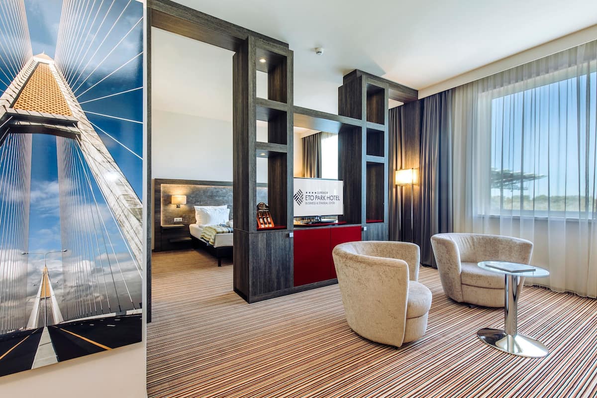Um hall de hotel com design moderno, com balcão de recepção, área de estar e uma janela ampla com vista.