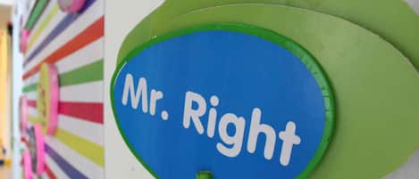 Uma parede com uma placa que diz "Mr. Right" e decorações coloridas listradas.