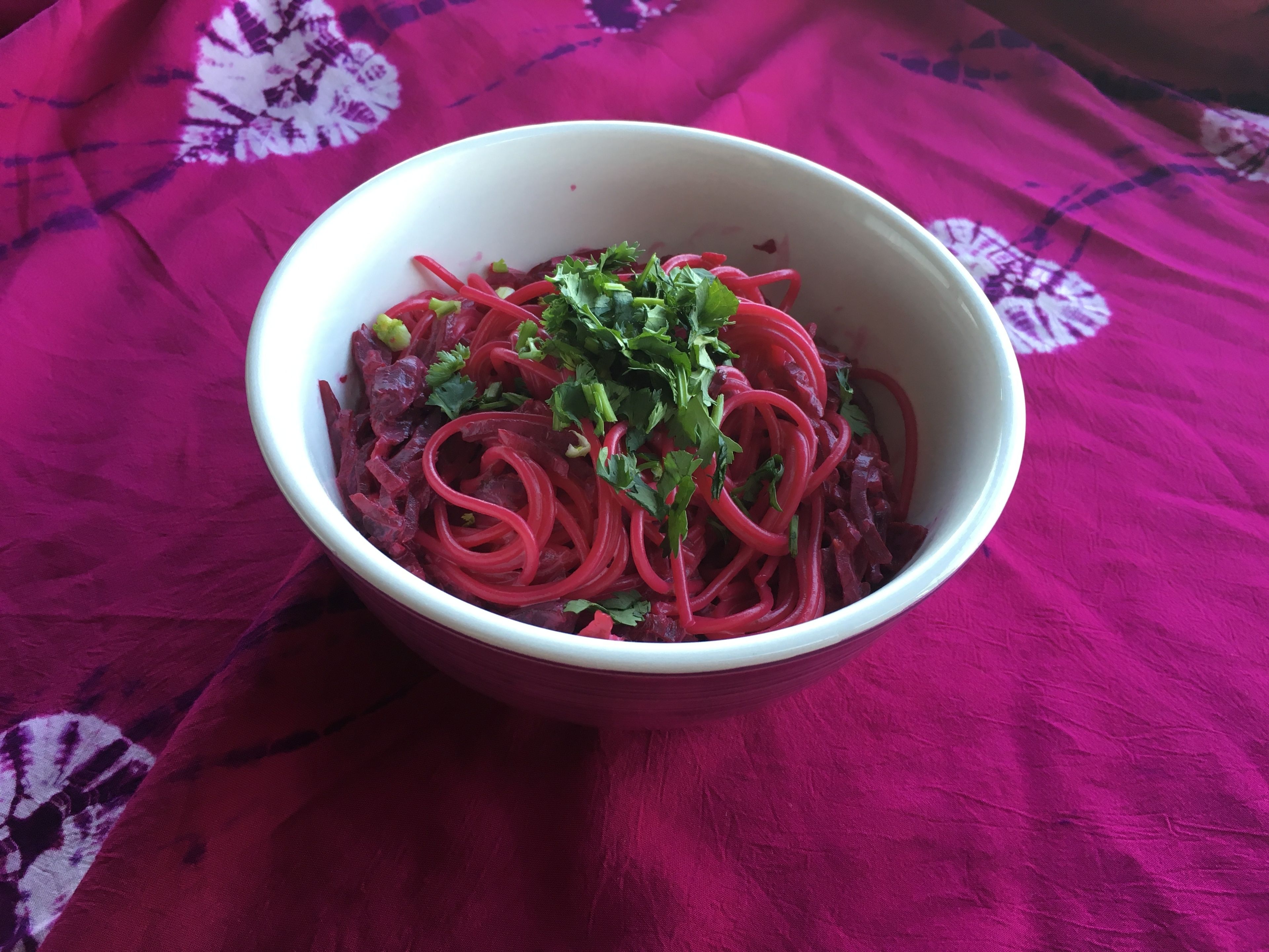 Uma tigela de comida sobre uma mesa com um tecido rosa.