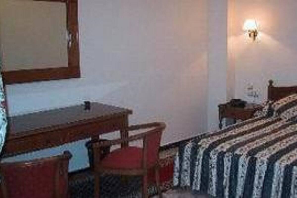 Quarto com uma cama, uma mesa e uma cadeira.