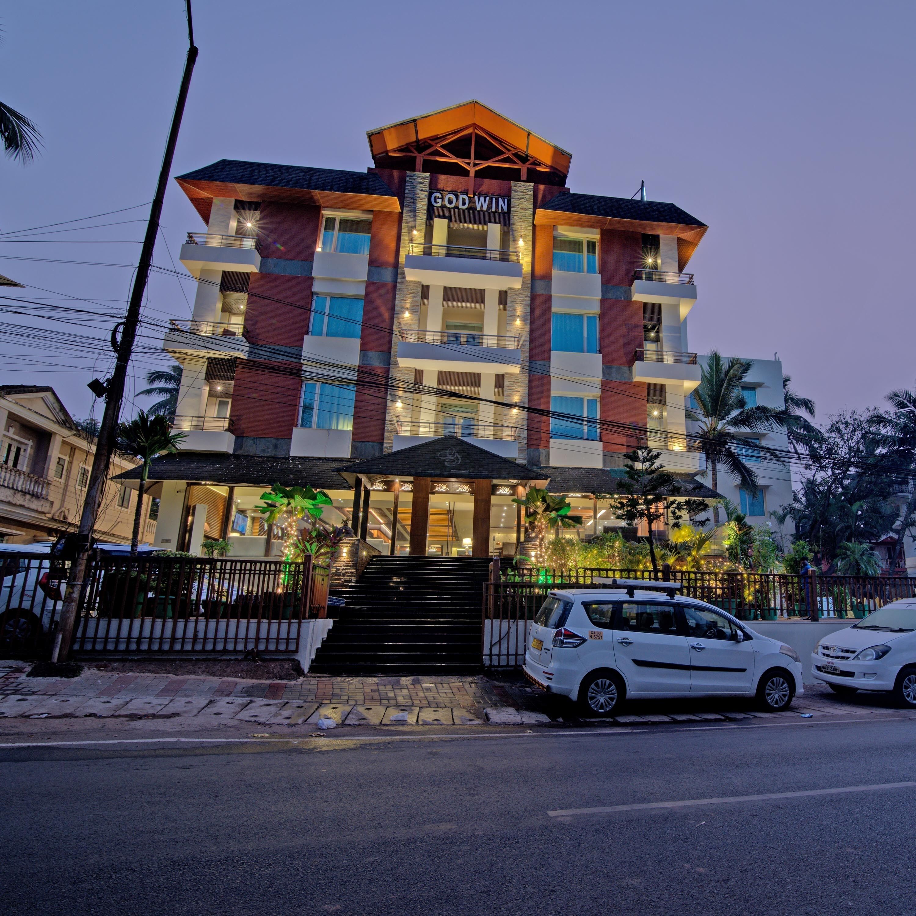 Um hotel com vários andares e um letreiro chamativo com a palavra 'GODWIN' no topo.