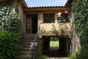 Uma escadaria de pedra que leva a uma casa com porta e janelas de madeira.