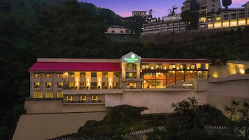 Um edifício de vários andares com telhado vermelho e uma placa que diz 'lemon tree resort'.