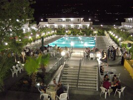 Uma área à beira da piscina com mobiliário de exterior e piscina.