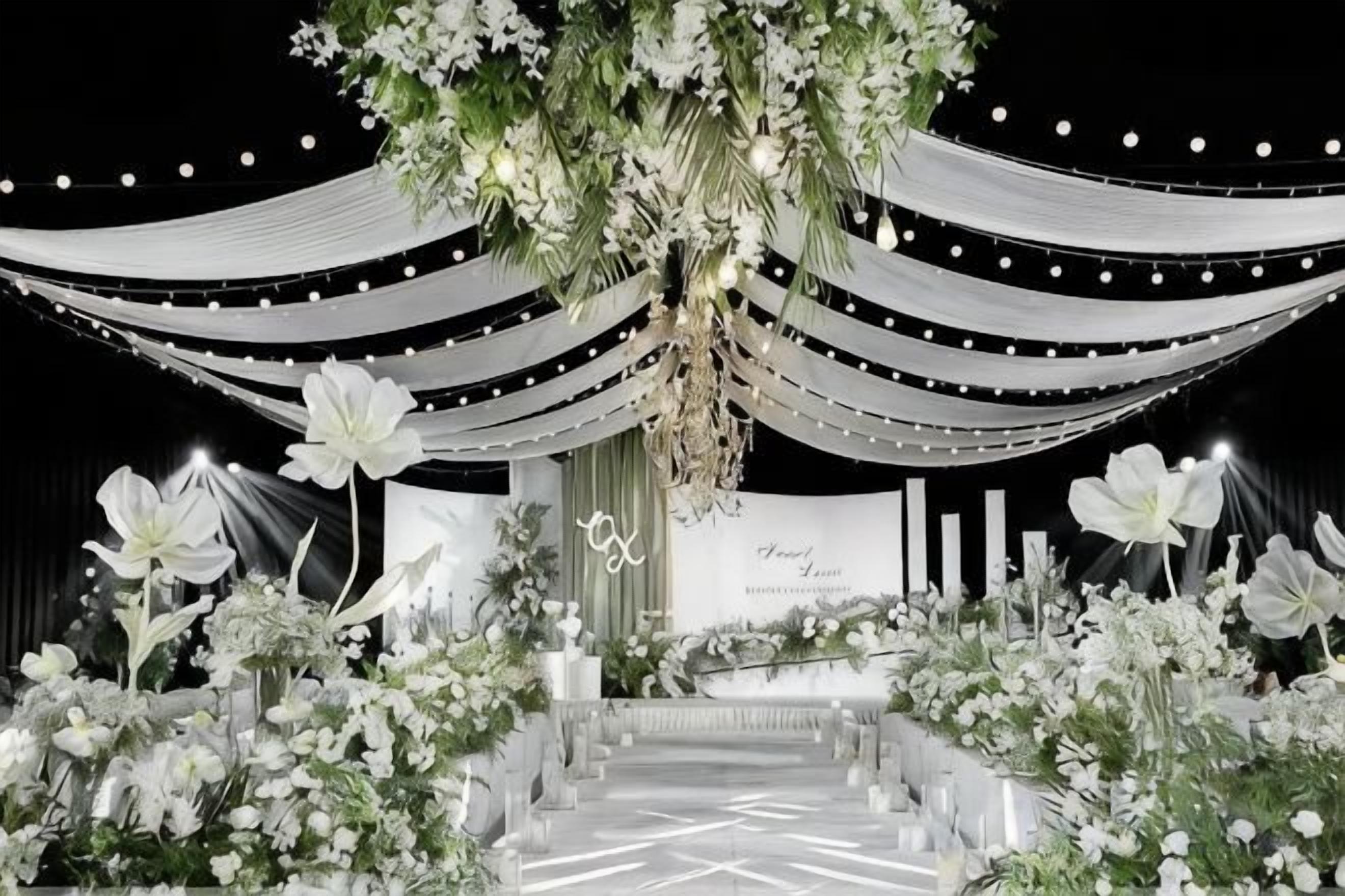 Palco com arranjo floral e tecido drapeado.