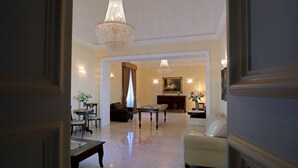 Uma sala de estar ampla com mesa de bilhar, sofá e lustre.