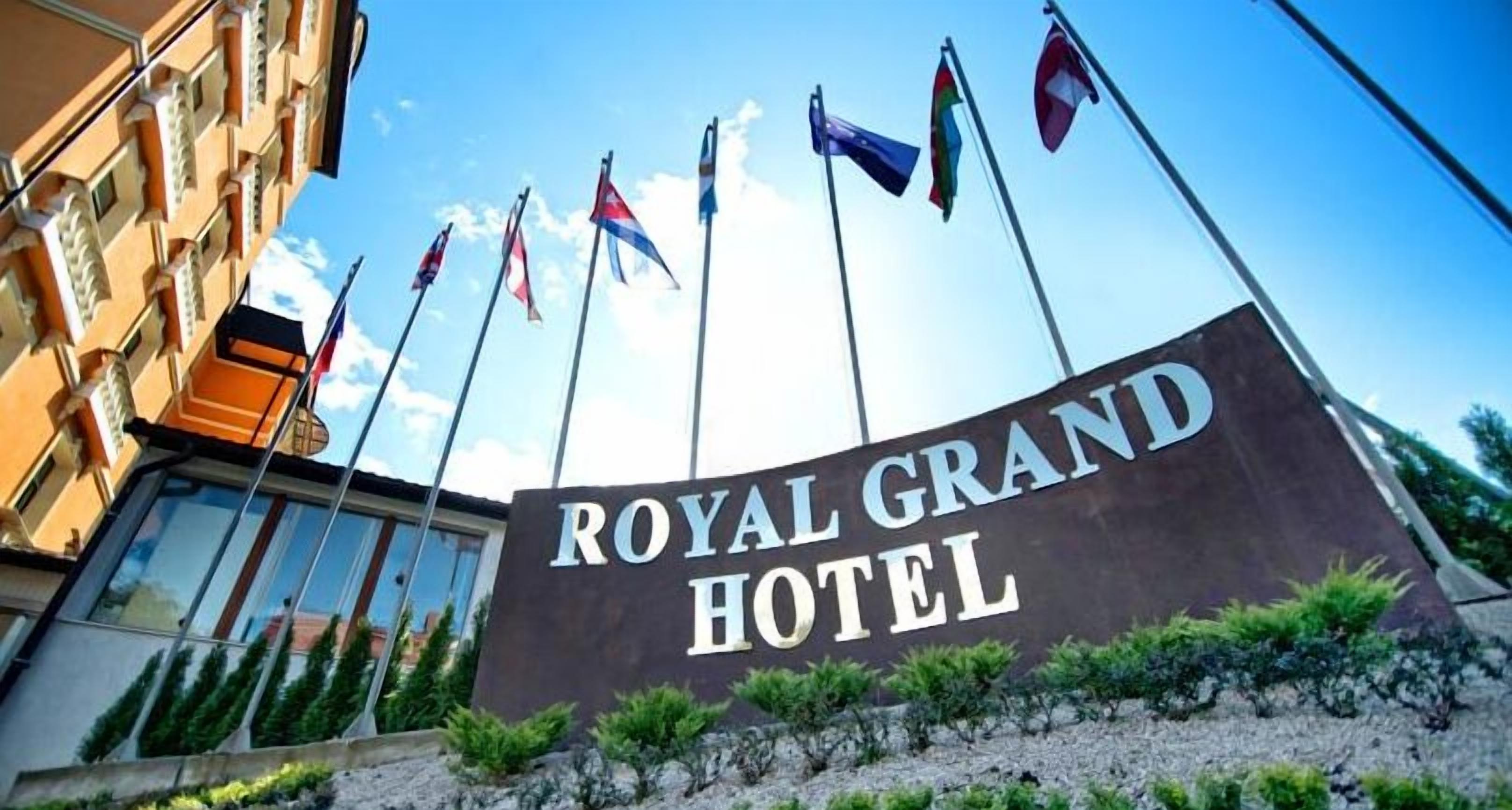 Exterior do Royal Grand Hotel, com o nome em destaque numa placa.