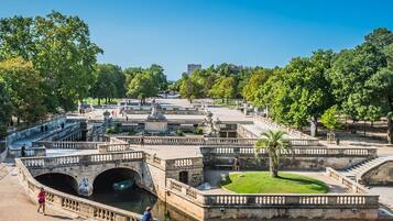Um parque histórico com pontes de pedra, estátuas e um canal.