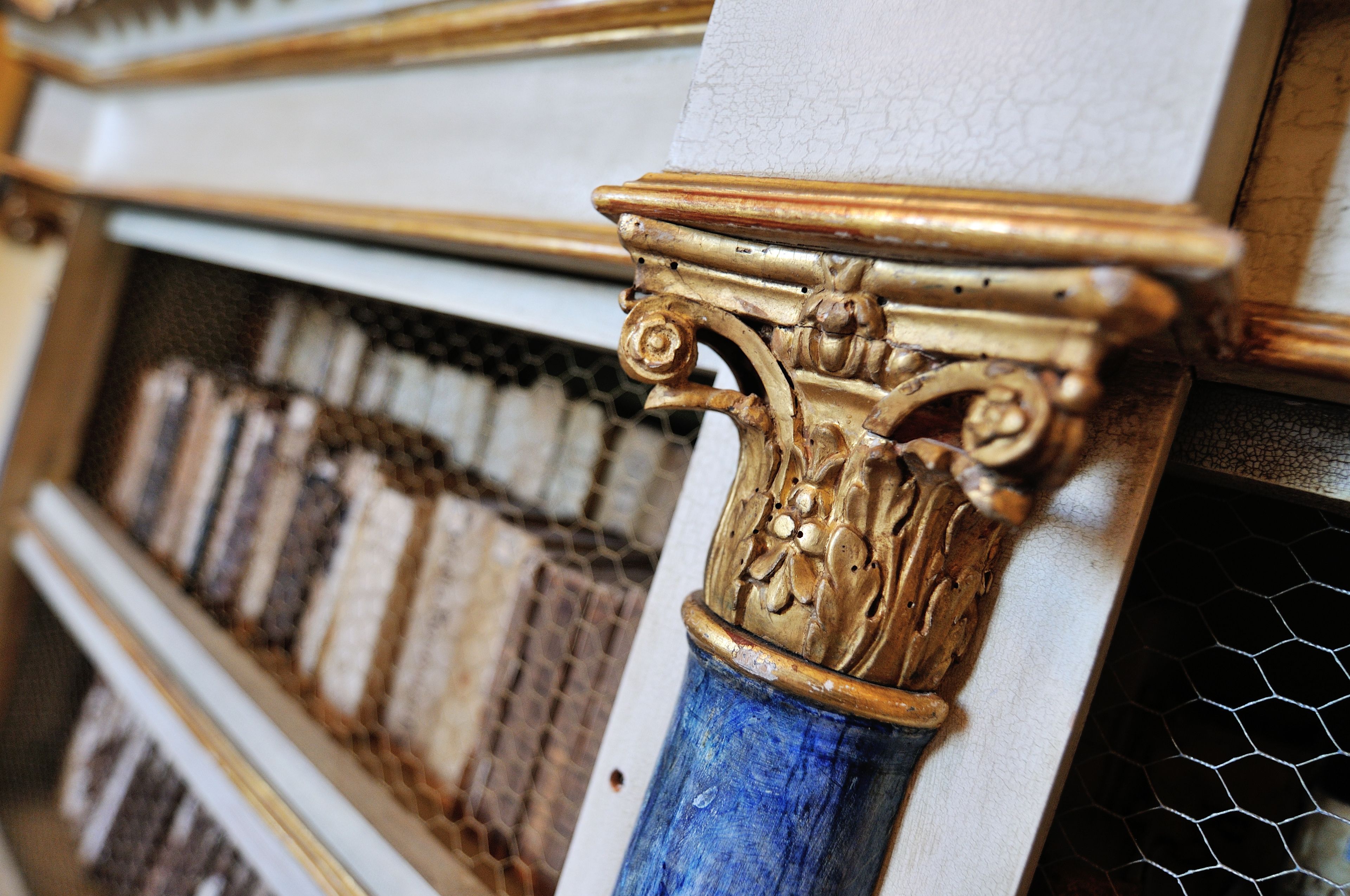 Um close-up de um pilar decorativo com esculturas detalhadas e base azul.