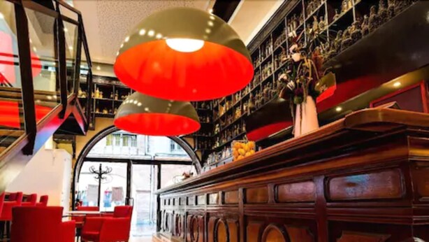 Uma área de bar com cadeiras vermelhas e um balcão de madeira.