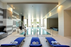 Área de piscina com espreguiçadeiras e aviso de proibição de mergulho.