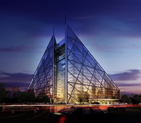 Um edifício moderno com fachada de vidro e design geométrico.