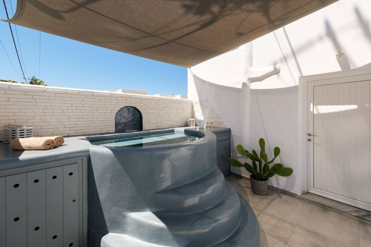 Uma área de spa com hidromassagem, um porta-toalhas e um vaso de plantas.