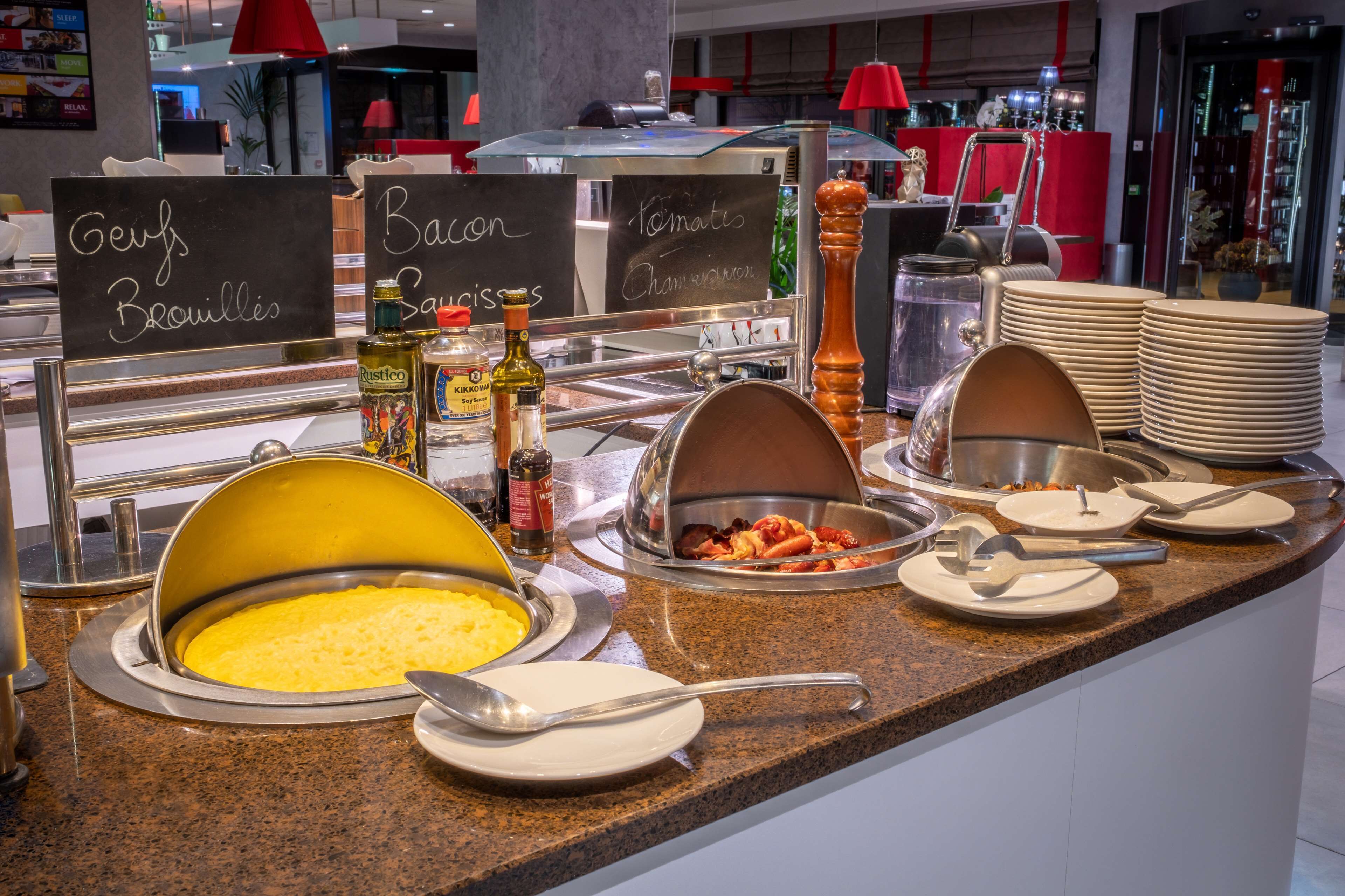 Balcão de buffet com estações de comida identificadas para Gefus, Bacon e Tomates.