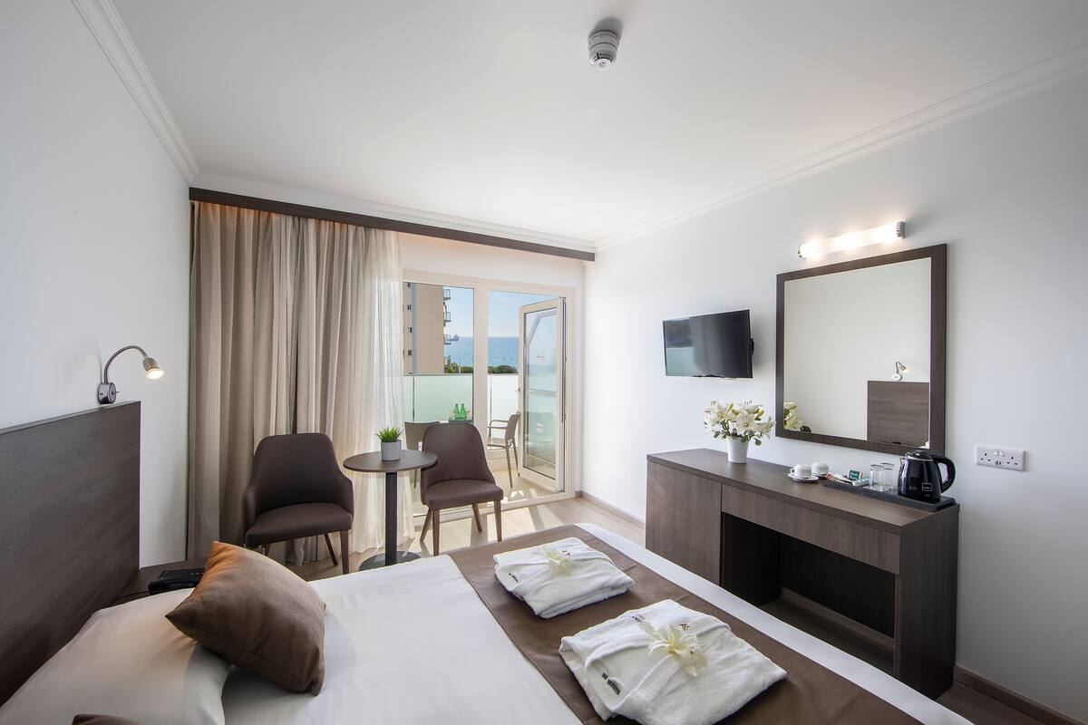 Quarto Superior, vista parcial para o mar | Minibar, ferro/tábua de engomar, Wi-fi grátis, roupa de cama fornecida 
